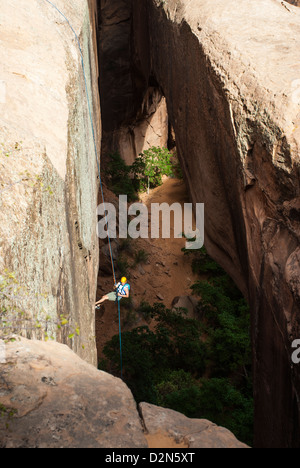 Tourist hanging on a rope while Canyoning in the area of the slick rock ...