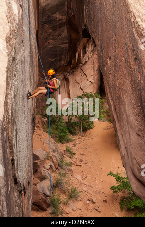 Tourist hanging on a rope while Canyoning in the area of the slick rock ...