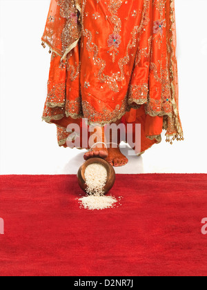 Bride kicking a rice filled pot in griha pravesh ceremony Stock Photo ...