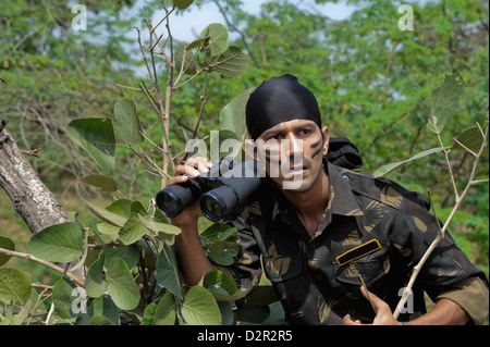 Soldier holding binoculars in a forest Stock Photo - Alamy