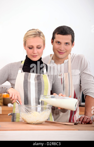 Mixing together butter and sugar in mixing bowl, using electric mixer ...