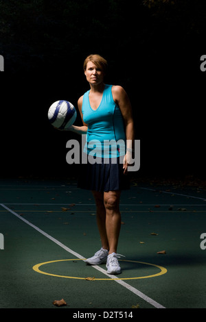 Portrait of netball player holding ball Stock Photo - Alamy