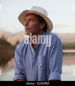close up of pensive and retired man looking away while touching face ...