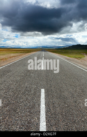 An empty desert road with dark and foreboding storm clouds on the ...