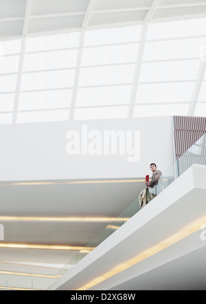 A Hispanic male standing inside the modern bus wearing a black face ...