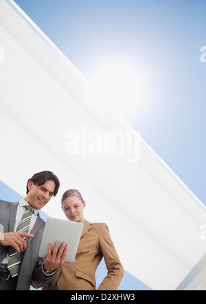 Smiling businesswoman using tablet computer at desk in home office ...