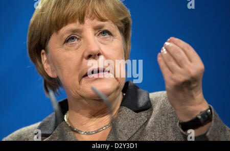 German Chancellor Angela Merkel holds a baby doll in her hands at the ...