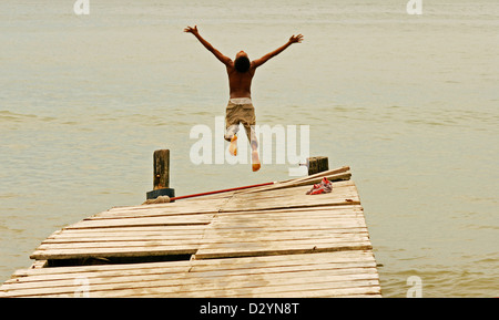 Colombia, Tierrabomba, view of young boys jumping off jetty into water ...