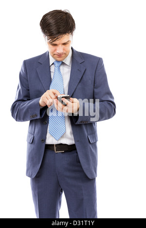 Young businessman sending text messages while standing in the city ...