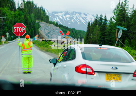 Flagger, or flag person, stops traffic for construction on Highway 1 ...