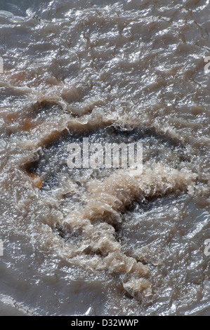 road gully, overflowing. flash flood, heavy rainfall, swirling ...