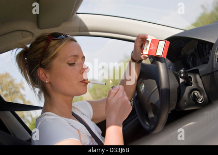 Woman smoking cigarette when driving Stock Photo - Alamy