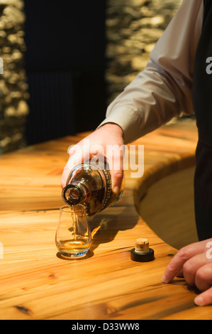 A tour guide pouring a complimentary dram in the Tasting Room of the ...