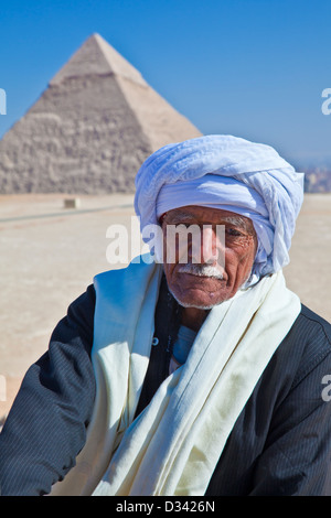 An elderly Arab on the Giza plateau, Egypt, with the Great Pyramids of ...