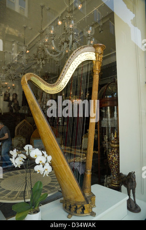 An antique harp on display in an Antiques dealers' window in the ...