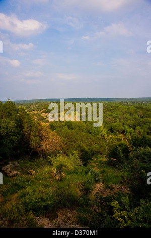 A scenic overlook of the Texas Hill Country reveals a lush valley with ...