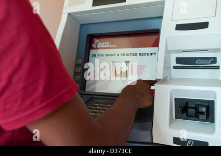 Man using an ATM automated banking machine at a Canadian Imperial Stock ...