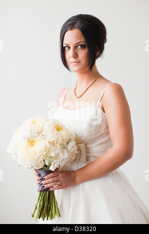 Vertical shot of a bride holding a beautiful bouquet walking on a ...