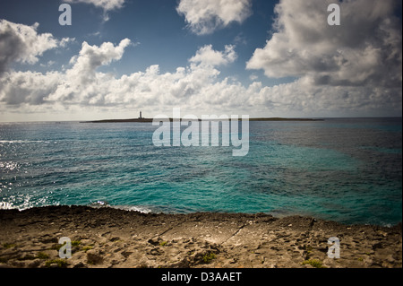 View of the lighthouse at Punta Prima with Clouds and sun above the sea ...