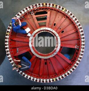 (dpa) - Enercon employees are working on the stator of a wind generator ...