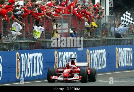 (dpa) - A crowd of cheering formula one fans wave flags with the logo ...