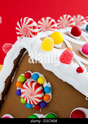 Decorated gingerbread house on red background Stock Photo - Alamy