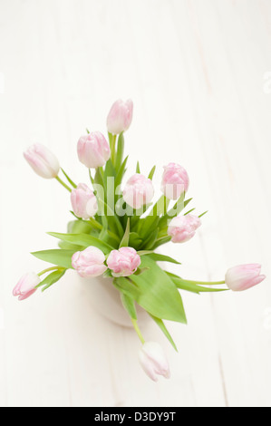 Still-Life of pale pink tulips in green vase on windowsill with sheaf ...