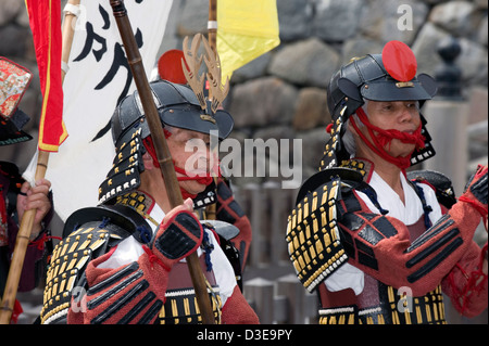 Samurai warriors wearing traditional armor crossing moat bridge at ...
