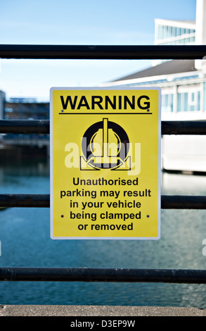 no unauthorised parking wheel clamp in operation release fee sign on a ...
