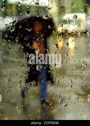 A man seen walking in rain and tander storm disrupted commute. (Photo ...