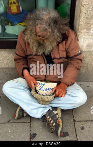 Hungry homeless man with 'I am hungry' sign sitting on the pavement and ...