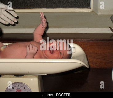 A crying baby girl is being weighed at the hospital after birth Stock ...