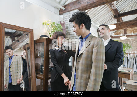 Local Chinese bespoke clothes shop business owner and assistant giving ...