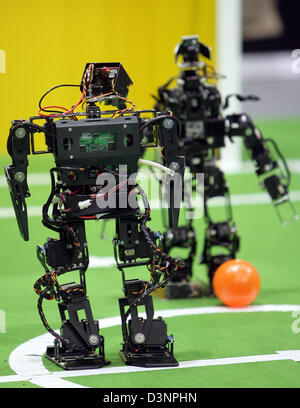 Humanoid robots take part in a football kickaround with a human in ...