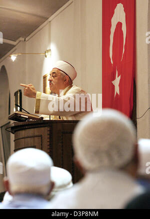 An imam speaks to Turkish muslims prior to the Friday prayer during the ...