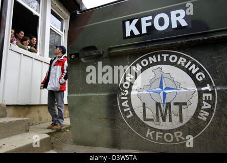 The logo of the Liaison Monitoring Team (LMT) pictured at the door of a KFOR vehicle in ...