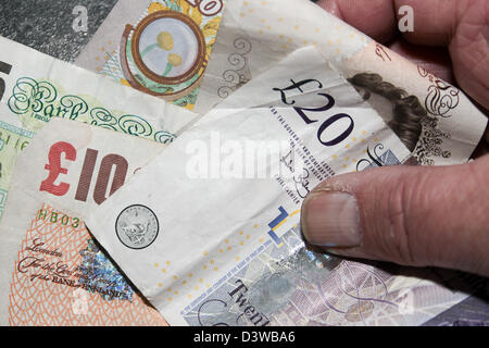 thumb holding british pound notes Stock Photo - Alamy