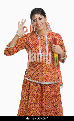 beautiful young woman making ok or approval symbol with hand with blue ...