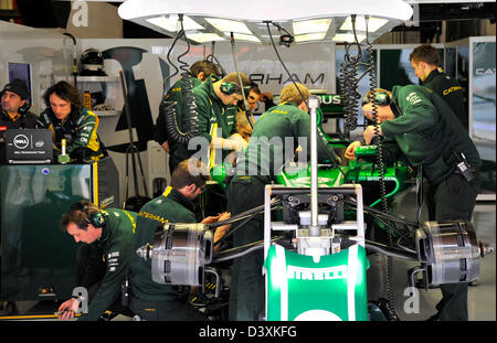 F1 mechanics at work on a F1 race car in the pit lane workshop ...