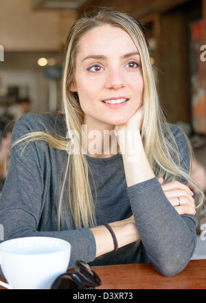 Attractive young lady having coffee at a cafe Stock Photo - Alamy