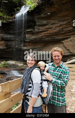 Smiling woman standing by waterfall Stock Photo - Alamy