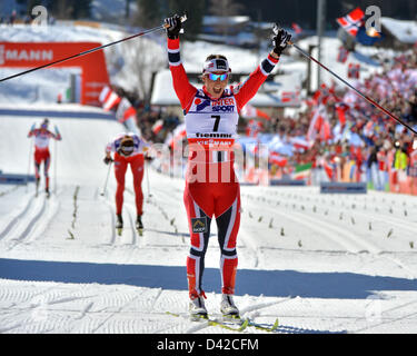 Marit Bjoergen, of Norway, celebrates as she crosses the finish line to ...