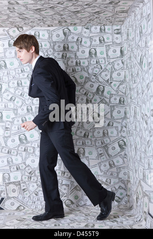 Businessman running away from dollar ball Stock Photo - Alamy