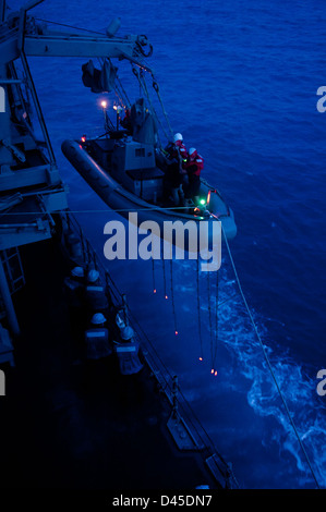 US Navy Sailors launch a rigid-hull inflatable boat during a man ...