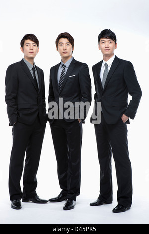 three businessmen in buisness suits posing in a line Stock Photo - Alamy