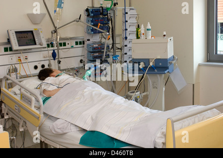 A woman on a life support system in a hospital intensive care unit ...