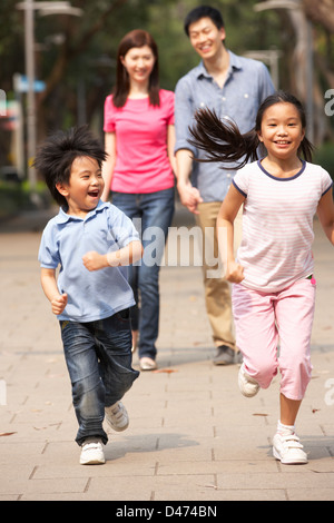 Happy Chinese children holding hands running in woods Stock Photo - Alamy