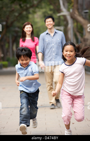 Happy Chinese children holding hands running in woods Stock Photo - Alamy