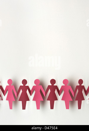 Pink cut out paper chain female figures against a white background ...