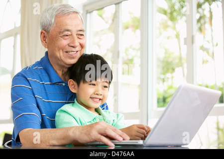 Grandfather and grandson using laptop at home Stock Photo - Alamy